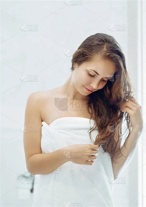 肖像美丽的年轻女性模特在沐浴应用发油。特写性感女人在毛巾干燥湿长发。健康与美容理念。保护保湿。素材 花瓣网