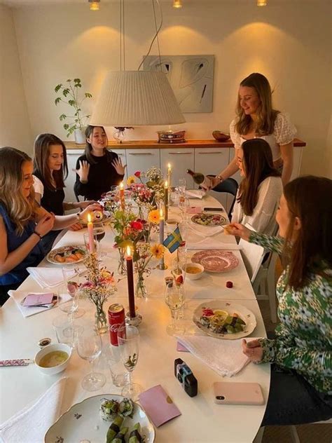 A Group Of Women Sitting Around A Table With Plates Of Food And Drinks