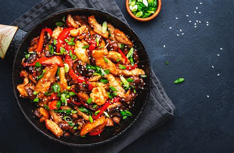 아시아 요리는 프라이팬에 튀긴 닭고기 파프리카 버섯 골파와 참깨를 넣고 볶습니다 검은 식탁 배경 평면도 미식가에 대한 스톡 사진 및 기타 이미지 Istock