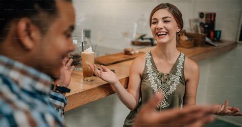 트렌디한 커피숍의 바 카운터에서 웃고 있는 아름다운 세대 Z 소녀는 혼혈 남자와 표현력이 있다 사진 Unsplash의 마시다 이미지