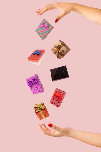 최소한의 구성 여성은 분홍색 배경에 선물과 선물 상자의 더미와 손 크리스마스 또는 생일 현대 개념 단일 이미지에 대한 스톡 사진