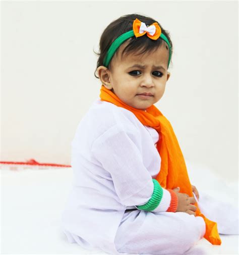 흰색과 주황색 긴 소매 셔츠와 흰 바지를 입은 소녀가 하얀 모래 위에 앉아 있다 사진 Unsplash의 무료 인도 이미지