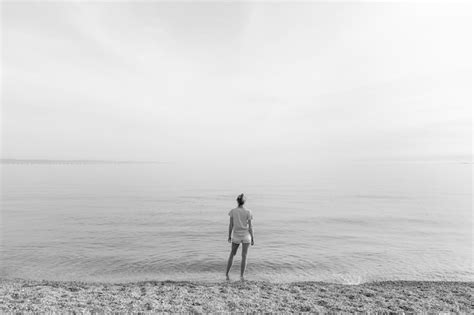 Premium Photo Rear View Of Man Standing On Beach Against Sky