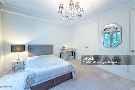 닫힌 흰색 나무 문과 고급스러운 마스터 홈 침실 인테리어 현대적인 집 아름다운 인테리어 킹 사이즈 침대 과일이 있는 테이블 럭셔리 램프 광고 미러 0명에 대한 스톡 사진 및