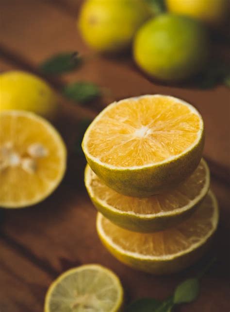 나무 표면 위의 신선한 레몬 슬라이스 · 무료 스톡 사진