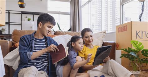 이동 홈 개념 아시아 가족 휴식 여가 시간은 골판지 상자 및 물건과 함께 앉아 아빠 엄마 딸은 홈 아파트 이동을 위한 가구 포장을 마친 후 함께 시간을 보냅니다 사진