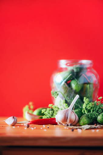 오이를 캔에 절인다 붉은 배경에 절인 거킨 유리 항아리 마늘 딜 소금 후추의 재료 공간을 복사합니다 야채 보존의 개념 건강한 생활방식에 대한 스톡 사진 및 기타 이미지