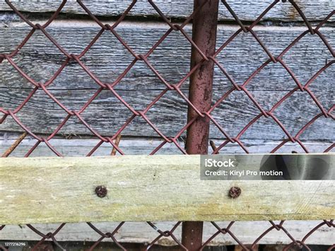 질감 금속 메쉬 그물에 못을 박은 나무 막대기가 있습니다 수제 울타리 손상 부식 및 녹이있는 녹슨 메쉬 보드는 녹슨 오래된 손톱으로 못을 박았다 0명에 대한 스톡 사진 및