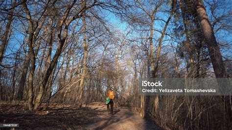 배낭과 용감한 백인 남자의 하이킹의 뒷 보기는 시골 길을 따라 숲으로 산책 가을에는 날씨가 좋고 태양이 상승 합니다 사람들이 없는 숲 멋진 휴식 깨끗 한 생태 가방에 대한