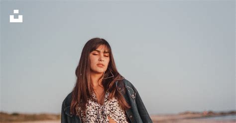 검은 가죽 재킷과 회색 데님 청바지를 입은 여자가 낮에 회색 모래 위에 서 있다 사진 Unsplash의 무료 세션 이미지