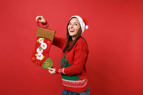 행복 한 산타 소녀 니트 스웨터에서 크리스마스 모자 찾고 스타킹 양말 선물 빨간 배경에 고립에 대 한 만요 행복 한 새 해 2019 축 하 휴일 파티 개념입니다 복사 공간을