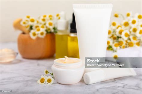 카모마일 스파 카모마일 꽃 수제 비누 에센셜 오일 화장품 병 바디 크림 스크럽 및 바다 소금이 흰색 질감 배경에 있습니다 편안한 뷰티 트리트먼트 복사 공간 건강관리와 의술에