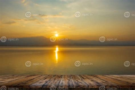 خرید و قیمت دانلود عکس میز خالی چوبی در غروب زیبای دریاچه اوپیک ترب