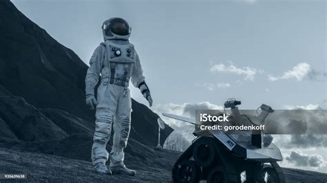 우주 비행사는 바위 외계 행성 탐험 탐험에 간다 백그라운드에서 그의 기지 및 Ai 구동 로버 미래 식민 개념입니다 우주 비행사에 대한 스톡 사진 및 기타 이미지 Istock