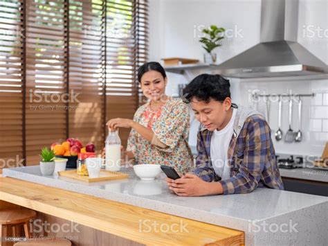 부엌에서 아침 식사를 하는 어머니와 아들 스마트폰을 사용하는 아들 12 13세에 대한 스톡 사진 및 기타 이미지 12 13세 2명 35 39세 Istock