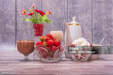 찻주전자 안경 음료와 잘 익은 딸기로 가득 찬 꽃병이 나무 테이블 위에 서 있습니다 긍정적 인 감정을 가진 정물 0명에 대한 스톡 사진 및 기타 이미지 Istock
