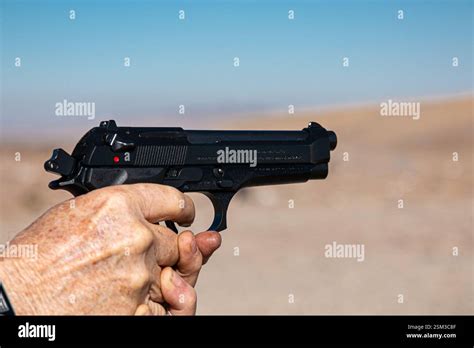 A Man Shoots A Black Semi Automatic Handgun During Target Practice Pistol Pointed To The Right