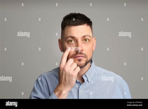 Man Checking His Health Condition On Grey Background Yellow Eyes As