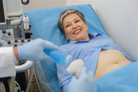 침대에 누워 병원에서 복부 초음파 검사를 받고 있는 중년 여성 환자 50 54세에 대한 스톡 사진 및 기타 이미지 50 54세 건강 진단 건강관리와 의술 Istock