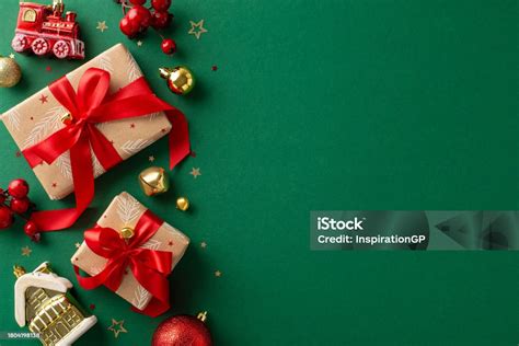 신년 준비 한창 활기찬 녹색 배경에 있는 평면도 공예 종이 선물 상자 빨간색과 금색 공 유쾌한 크리스마스 트리 장난감 겨우살이 열매와 색종이 조각이 축제 분위기를