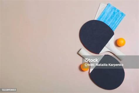 베이지 색 배경에 테니스 라켓 공과 의료 마스크의 최고 보기 검역 중 야외 엔터테인먼트 전염병 네트 스포츠 장비에 대한 스톡