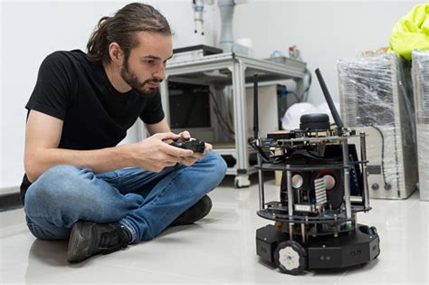 남성 엔지니어는 제조 자동화 및 로봇 강의실에서 Ai 로봇 및 사물의 인공 지능 서비스 로봇을 제어하거나 훈련합니다 20 24