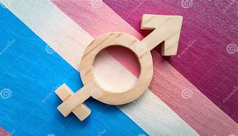 A Wooden Intersex Symbol On A Striped Background Of Pink White And Blue Generative Ai Stock