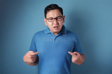Asian Man Pointing Himself With Unhappy Expression As If He Confused To Be Accused Stock Photo