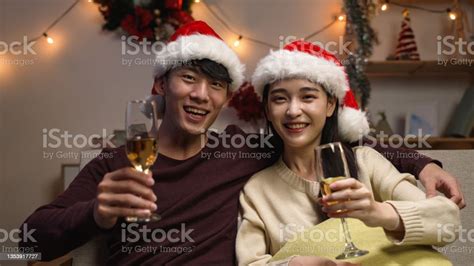 러브 로맨스 휴일 축하 컨셉 온라인 화상 통화 중에 소파에 앉아 빨간 산타 모자를 들고 와인 잔을 마시는 커플 화이트 와인과 함께 여성과 남성 토스트 를 기쁨 2명에 대한