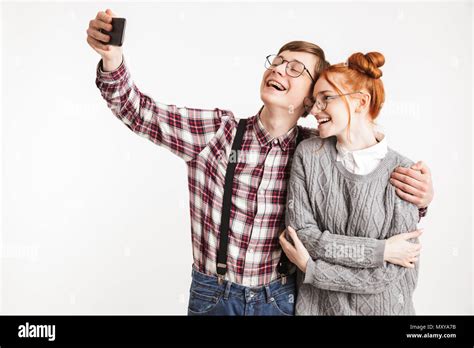 Happy Couple Of School Nerds Taking Selfie With Mobile Phone Isolated Over White Background
