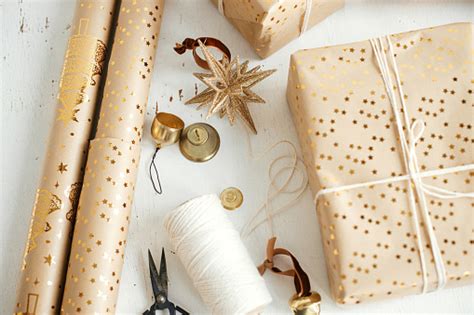 세련 된 황금 크리스마스 선물 플랫 누워 현대적인 포장 크리스마스 선물 상자 축제 종이 황금 장식품 및 흰색 나무 배경에 실 구성 즐거운 성탄절 가위에 대한 스톡 사진 및