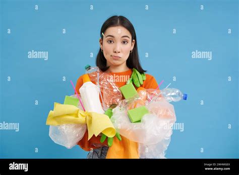 Young Confused Asian Girl With Different Types Of Plastic Learns How