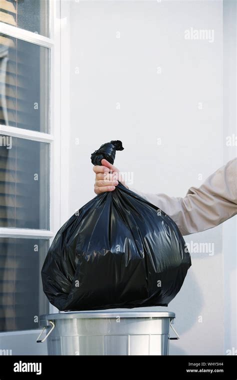 Closeup Of A Man Putting Garbage Bag Into Trash Can Stock Photo Alamy