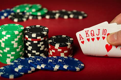 빨간 부지깽이 테이블에 가장 높은 이기는 조합 왕 홍조를 가진 트럼프패를 들고 있는 선수 손 클럽의 테이블에 있는 카드 놀이와 다양한 칩의 클로즈업 0명에 대한 스톡 사진