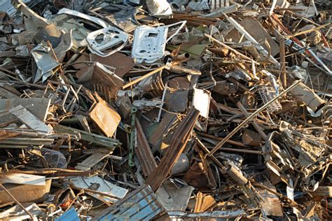 금속 스크랩 배경 재활용을 위해 저장된 고철 더미 창고에서 금속 폐기물 재활용 크레인을 잡으면 포트에서 고철을 내릴 수 있습니다