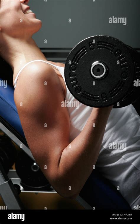 Girl Exercising Bicep Curl On A Bench In Gym Stock Photo Alamy