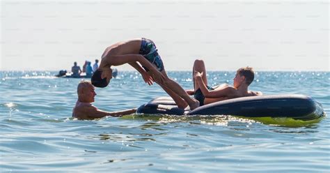 해변에서 휴가를 보내는 쾌활하고 행복한 가족 아버지와 할아버지는 바다 파도에서 아이들과 놀고 있습니다 여름 여행 및 야외 휴가 건강한 라이프 스타일 사진