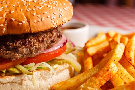 레스토랑에서 맛있는 햄버거를 닫습니다 참깨 빵 고기 패티 토마토 양상추와 피클 감자 튀김과 함께 제공 0명에 대한 스톡 사진 및