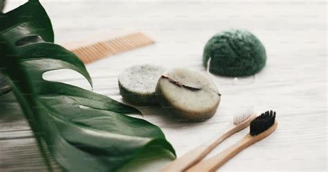 친환경 천연 대나무 칫솔 샴푸 바 유리에 든 치약 나무 브러시 녹색 몬스테라 잎이 있는 흰색 나무에 곤자쿠 스폰지 폐기물 제로 개념 플라스틱 무료 사진