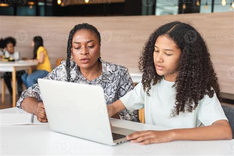 Female Teacher Assisting Student With Online Learning At Home Mother