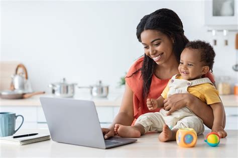 Premium Photo Black Mother Taking Care About Baby And Working On