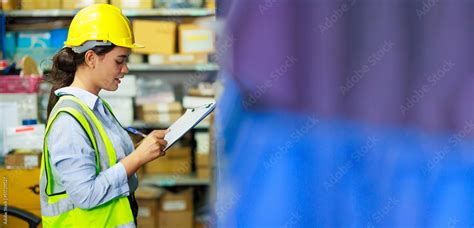 Happy Female Factory Manager Checking Order On Cardboard In Industrial Warehouse Factory