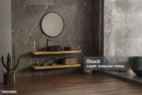 최소한의 목재 세면대 타원형 거울 검은색 세면대 대리석 세라믹 벽 콘크리트 바닥 식물과 바구니 욕실 액세서리 현대적인 무연탄 욕조가 있는 현대적인 욕실입니다 3d 렌더링