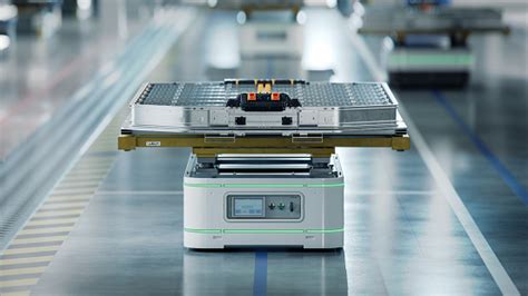 산업 환경에서의 무인 운반차 자율 Agv는 첨단 스마트 팩토리의 Ev 생산 라인에서 배터리 팩을 운송합니다 전기 자동차 제조 전기 자동차 조립 라인 공장 산업 건물에 대한