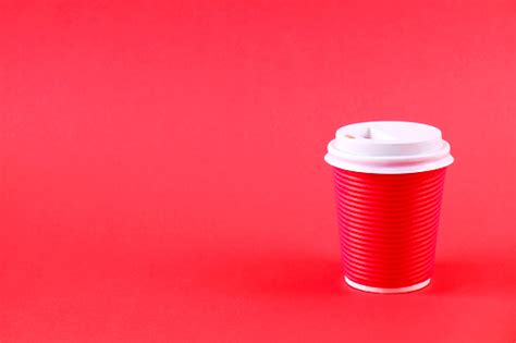 갈색 일회용 안전 내 열 두 배 벽된 종이가 커피의 컵을 꺼내 뜨거운 음료 밝은 빨간 배경에 백색 모자에 대 한 다채로운 에코