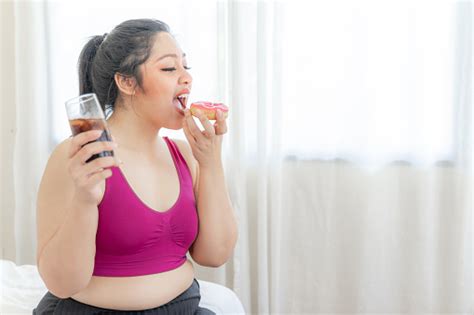 당신이 뚱뚱한 이유 침실 이유 침실 이유 라이프 스타일 여성 다이어트 체중 감량 오버더무게 정크 푸드 달콤한 치료 케이크와 달콤한 물을 먹는 초상화 아름다운 통통 젊은