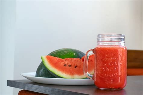 더운 화창한 날에 갓 준비한 수박 주스로 가득 찬 유리와 함께 다진 수박과 그 조각의 아름다운 그림 감기와 독감에 대한 스톡