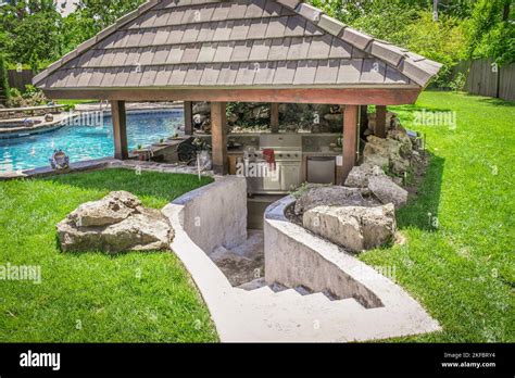 Outdoor Kitchen Sunken Into Ground By Swimming Pool To Create A Swim Up