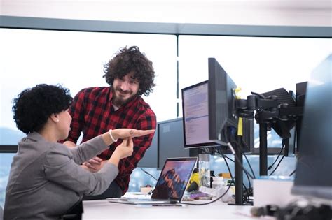 Premium Photo Young Software Developers Couple Using Laptop And Desktop Computer While Writing