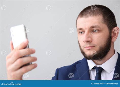 Man Unlocking Smartphone With Facial Scanner On Light Background Biometric Verification Stock